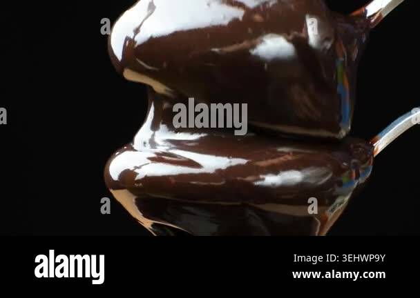 Slow motion of melted dark chocolate flow on black background Stock ...