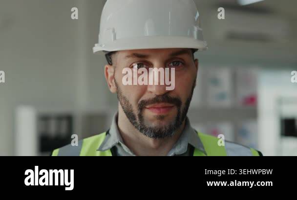 Portrait of Middle Eastern bearded engineer in hard hat and safety vest ...