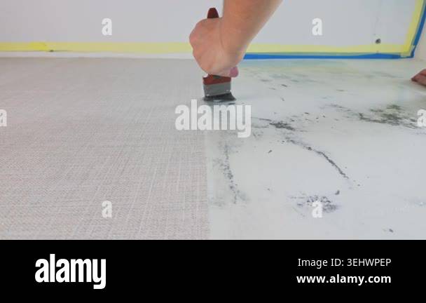 Worker applying wallpaper glue onto interior wall with brush Stock ...
