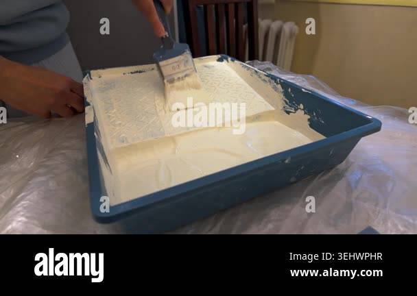 Person dipping paint brush into plastic tray indoors Stock Video ...