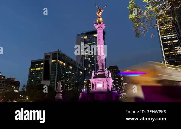 Red bus motion blur passing independence angel monument at night in ...