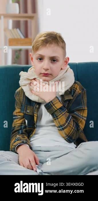 Attractive sad sick 12-aged child posing on camera on comfortable sofa ...