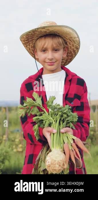Portrait of smiling caucasian male farmer boy worker holding organic ...