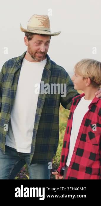 Farmer father son walking together in vegetables field. Man farmer ...