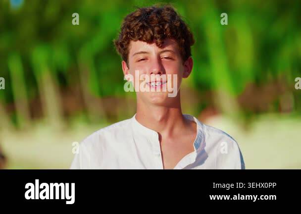 Portrait of a smiling teenage boy with braces, standing outdoors ...