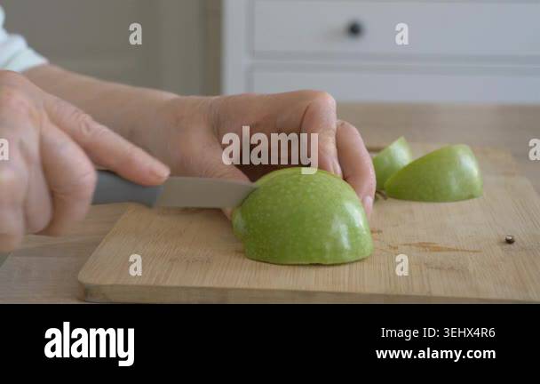 Old woman is cutting green apple. Closeup at hands Stock Video Footage ...