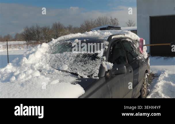 Winter. Woman is removing snow from a car. Slow Motion Stock Video ...