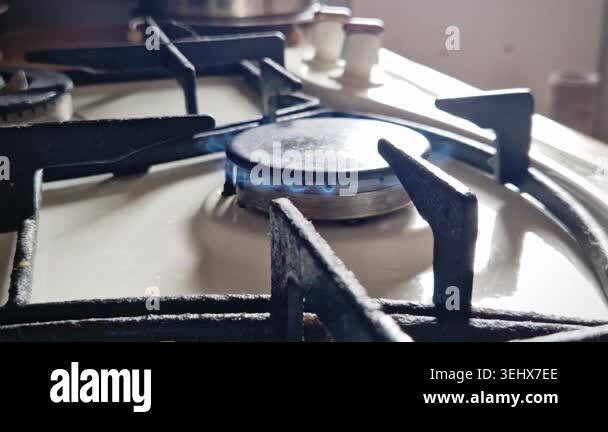 Close up shot of a gas burner on a white enamel stove surface with ...