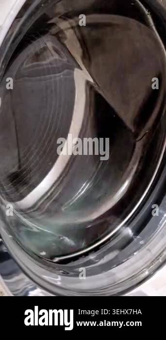 Vertical, close up view of an empty washing machine drum spinning ...