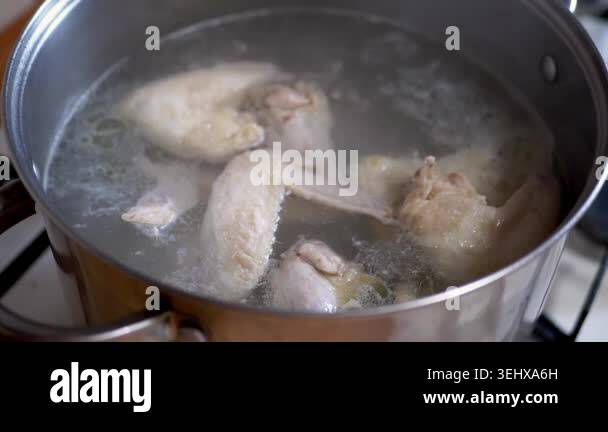 Close up, Fresh chicken wings are boiling in water, making them perfect ...