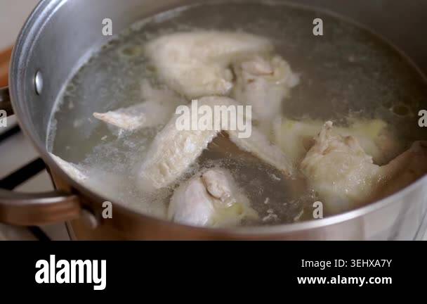 Close up, fresh chicken wings boiling in water, perfect for savory ...