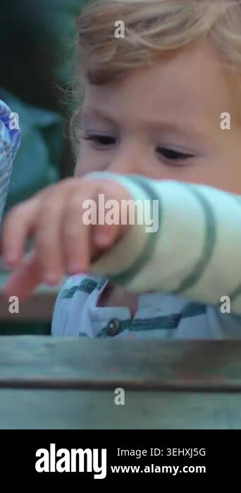 Young child extending hand toward salad plate at outdoor restaurant ...