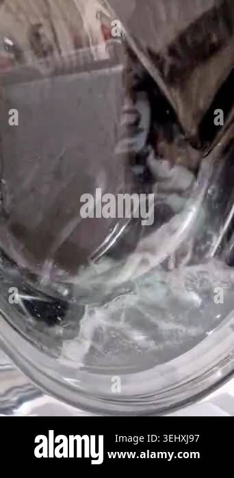 Vertical, close-up view of a front-load washing machine drum with clear ...