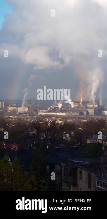 Large industrial factory complex emits heavy smoke from multiple ...