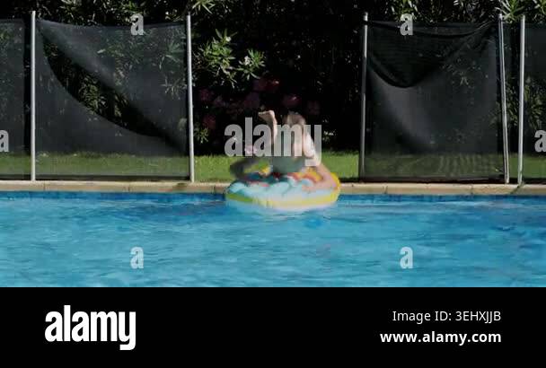 Boy jumps onto inflatable raft at edge of swimming pool then crashes ...