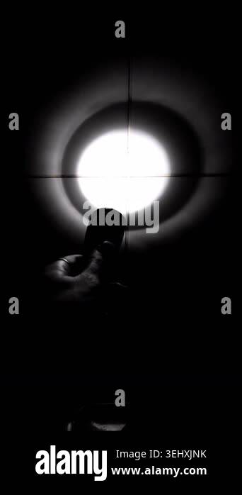 Hand holds a flashlight, illuminating a white tiled surface in a pitch ...