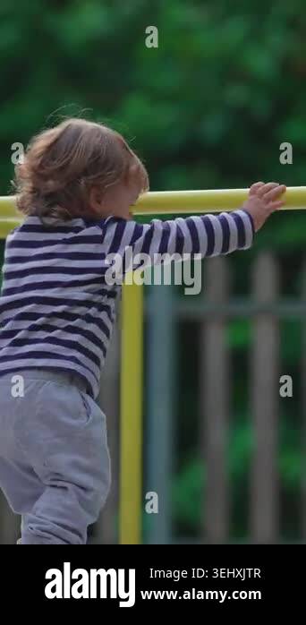 Toddler moving carefully under roundabout structure at public ...