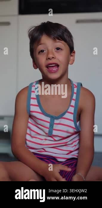 Young child looks toward camera while speaking casually during relaxed ...