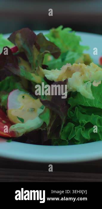 Colorful mixed vegetable salad presented at outdoor dining table ...