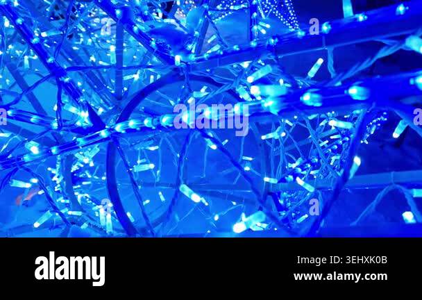 An intricate network of bright blue LED lights covers a geometric metal ...