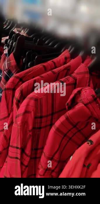 Red plaid Christmas shirts with festive patterns hang on a clothing ...
