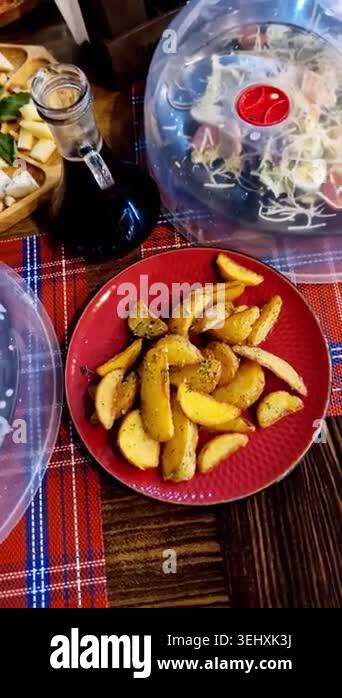 Roasted potato wedges are presented on a red plate, beautifully ...