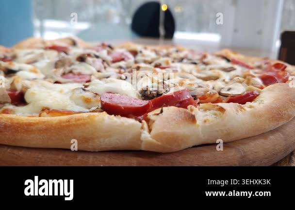 A close-up view of a hot pizza featuring savory sausage, earthy ...