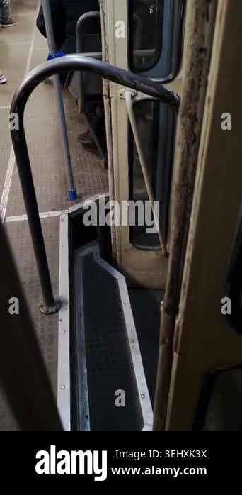 Worn metal steps and a safety handrail inside an old public transport ...