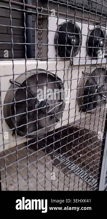 Large industrial ventilation fans of an HVAC system rotate behind a ...