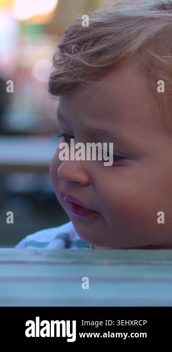 Young child tasting tomato during outdoor restaurant meal highlighting ...
