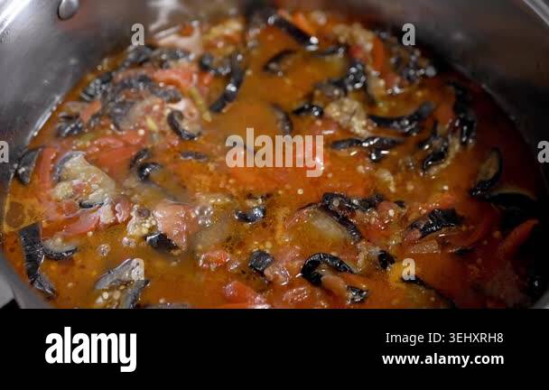 Close-up of a rich vegetable stew bubbling in a metal pot, featuring ...