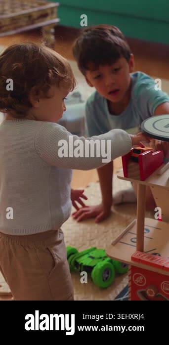 Young children playing together with miniature vehicle toys in cozy ...