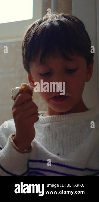 Young youngster having homemade bread snack indoors surrounded by cozy ...