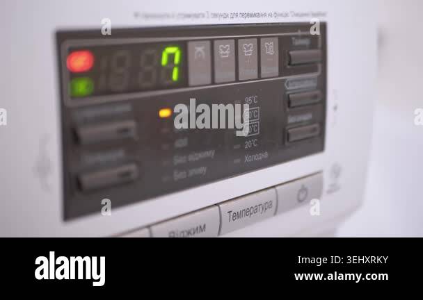 A close-up of a washing machine control panel displaying glowing ...