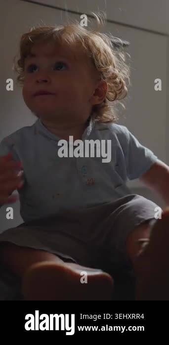 Young child lifting body from floor in cozy kitchen interior creating ...