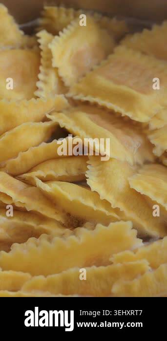 Filled pasta cooking in bubbling water inside metal saucepan ...