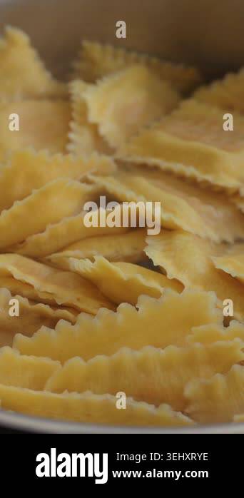 Fresh filled pasta simmering inside metal pot during classic ...