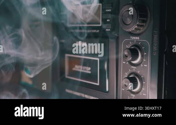 A close-up of a black vintage cassette recorder with analog dials ...