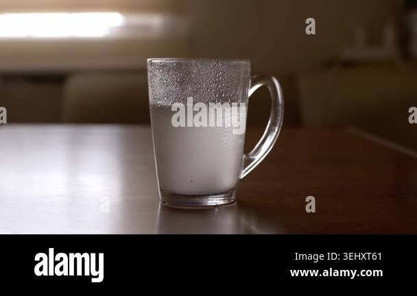 A clear glass mug filled with cold fizzy liquid and covered in ...
