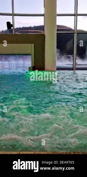 Bubbling turquoise water in a jacuzzi with colorful underwater lights ...