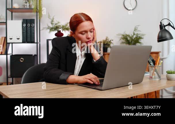 Young businesswoman at home office types report on laptop fighting ...