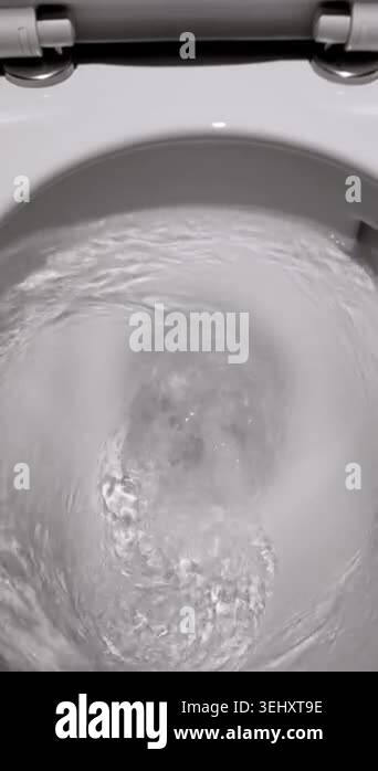 A close-up view captures water dramatically swirling and spiraling down ...