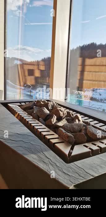 Modern decorative stone fireplace sits near a window overlooking a ...