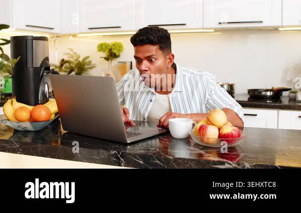 Indian man reacts with joy to success on laptop during home break in ...