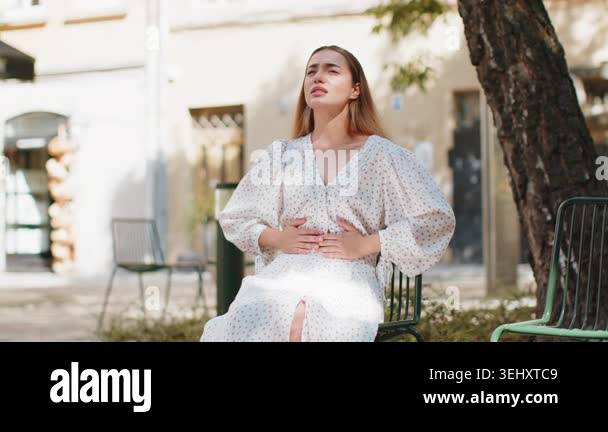 Caucasian young woman traveler feeling sudden strong abdominal stomach ...