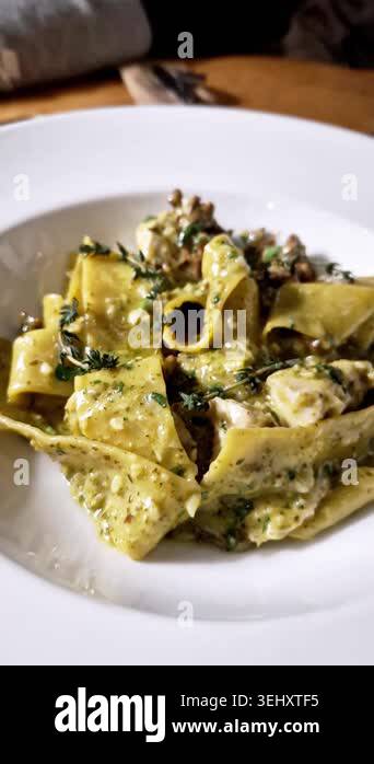 Fresh pappardelle pasta is coated in rich green pesto sauce with ...