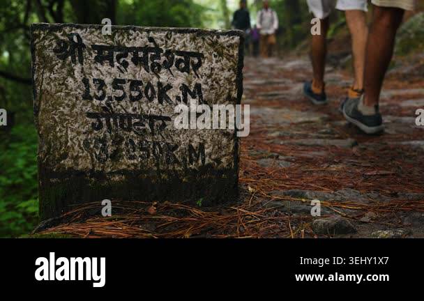 Close-up of weathered stone with carved script embedded in a mountain ...