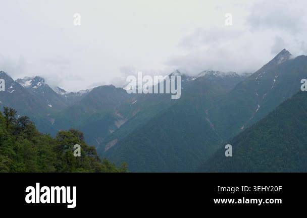 Panoramic view of cloud-covered peaks and lush green valleys in the ...