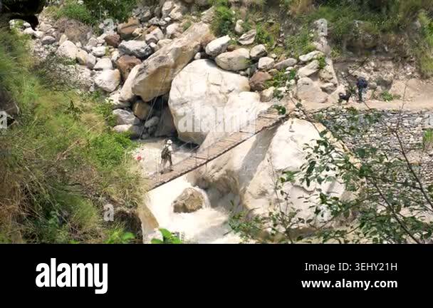 Clear water flowing over large boulders in a mountainous region with ...