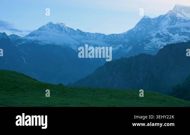 Panoramic view of misty mountain ranges with snow-covered summits and ...